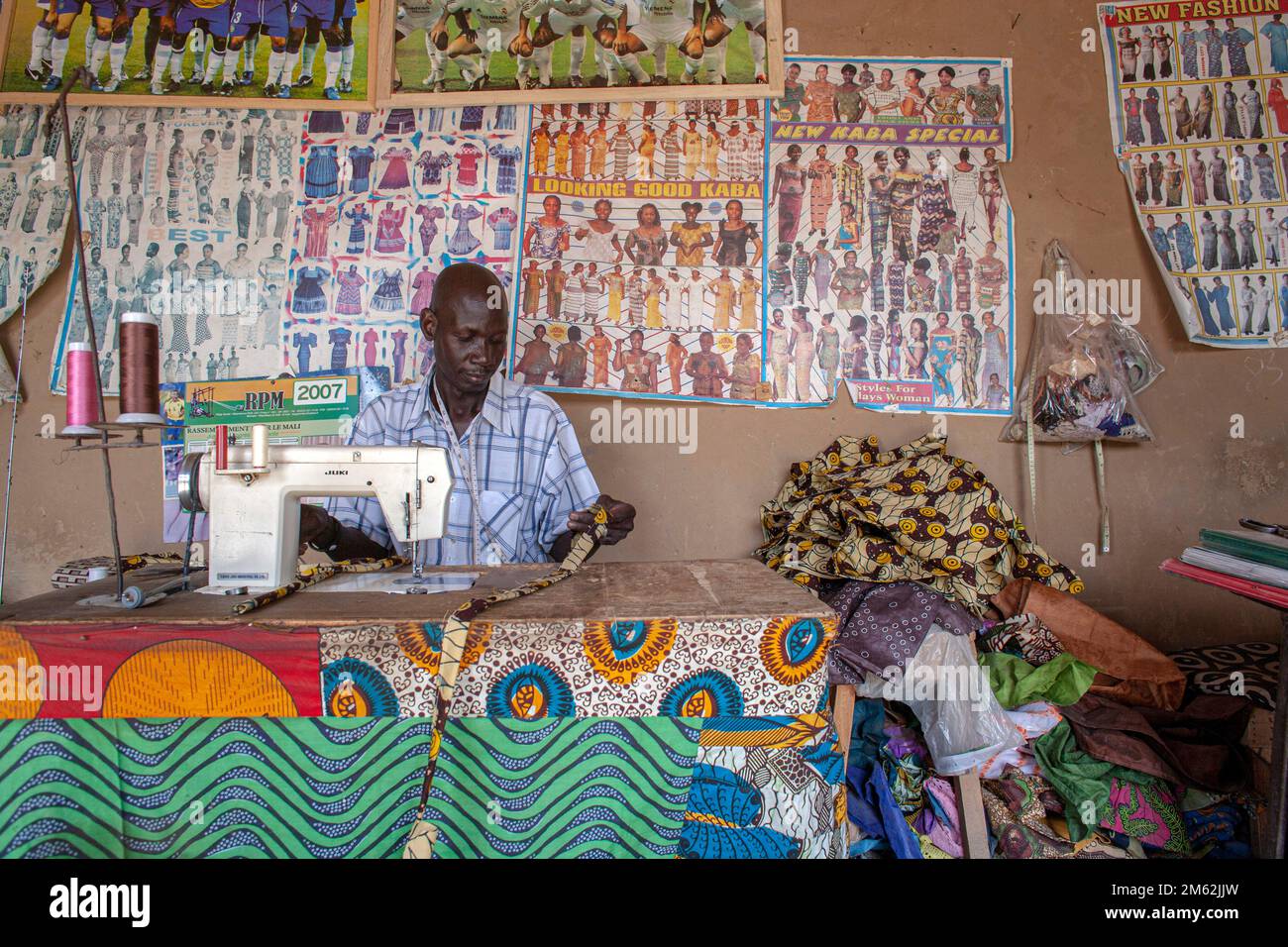 Portrait d'un jeune africain tailleur travaillant avec sa machine à ...