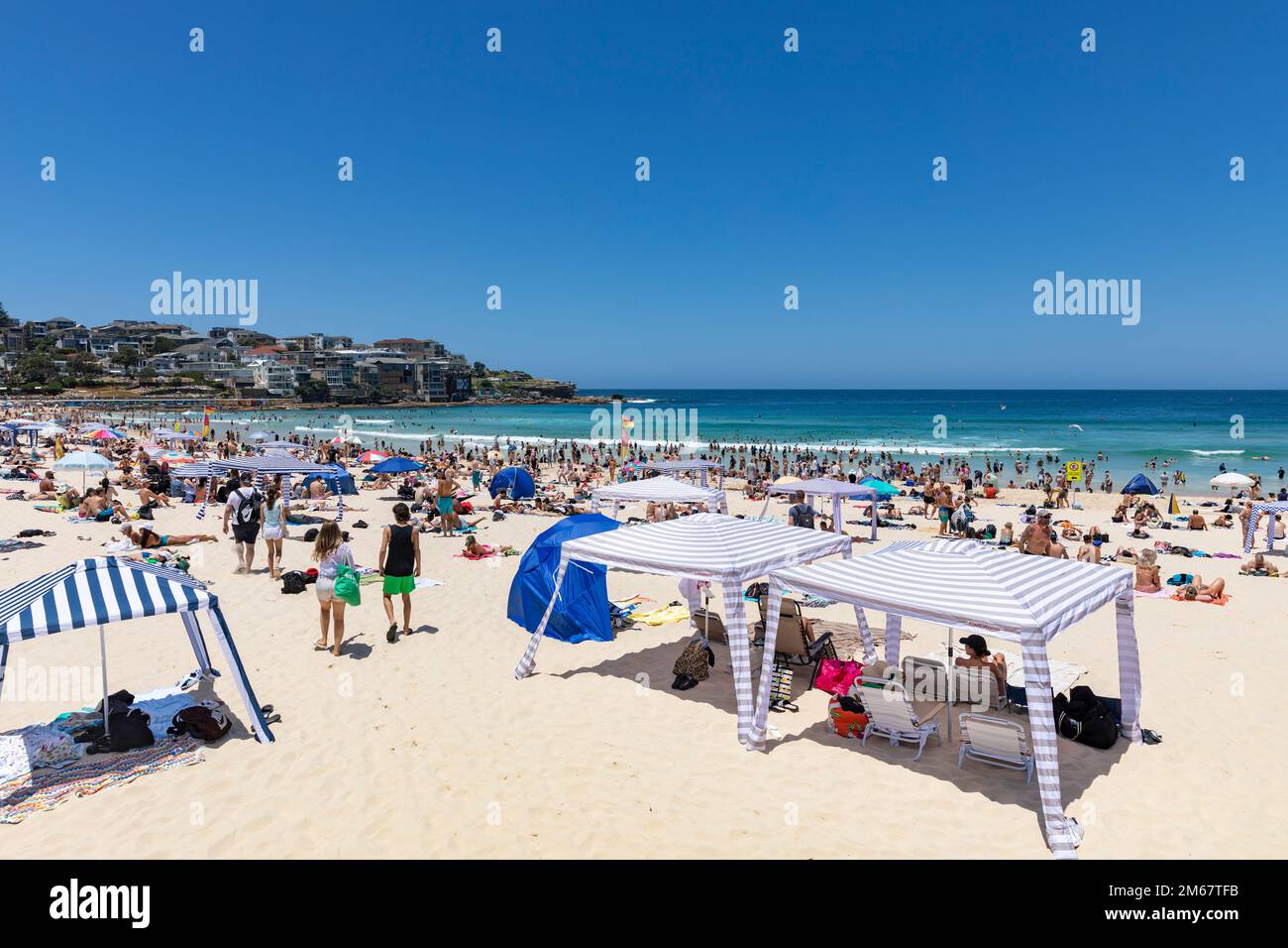 Bondi Beach à Sydney, le jour d'été 2023, plage bondée et gens dans l'océan, ciel bleu, banlieue ...