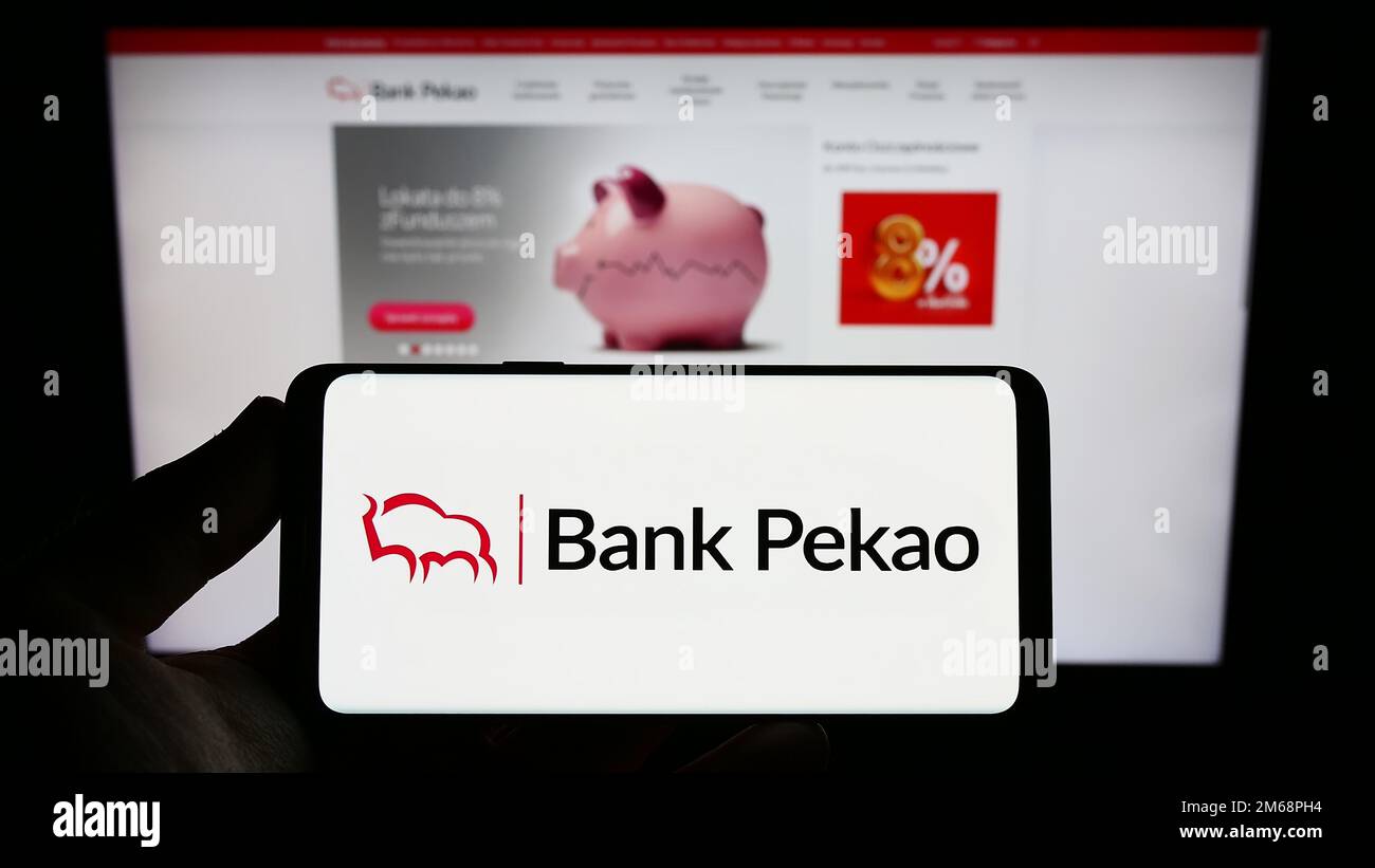 Personne tenant un smartphone avec le logo de la société financière ... Personne tenant un smartphone avec le logo de la société financière ...