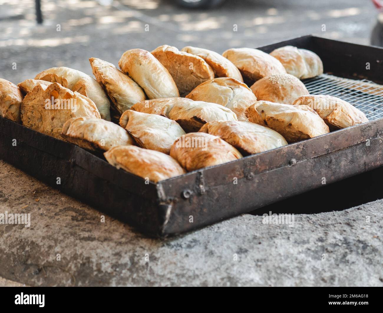 Petits pains frais et chauds posés sur un plateau près du poêle chaud ...