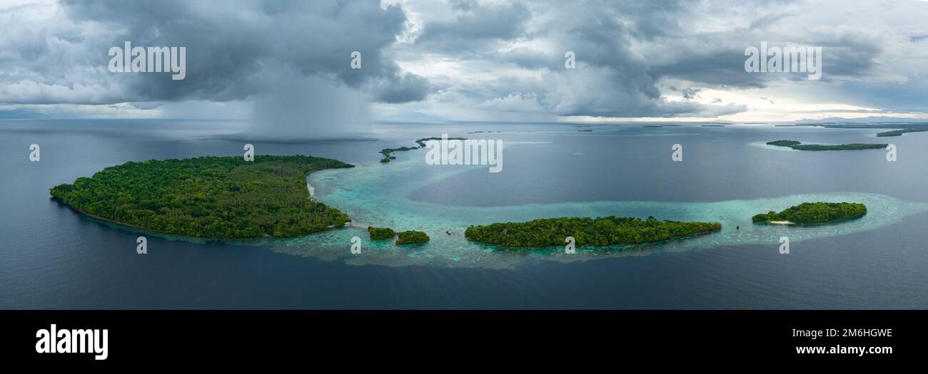 Les nuages de tempête déversent la pluie près d'une île tropicale ...