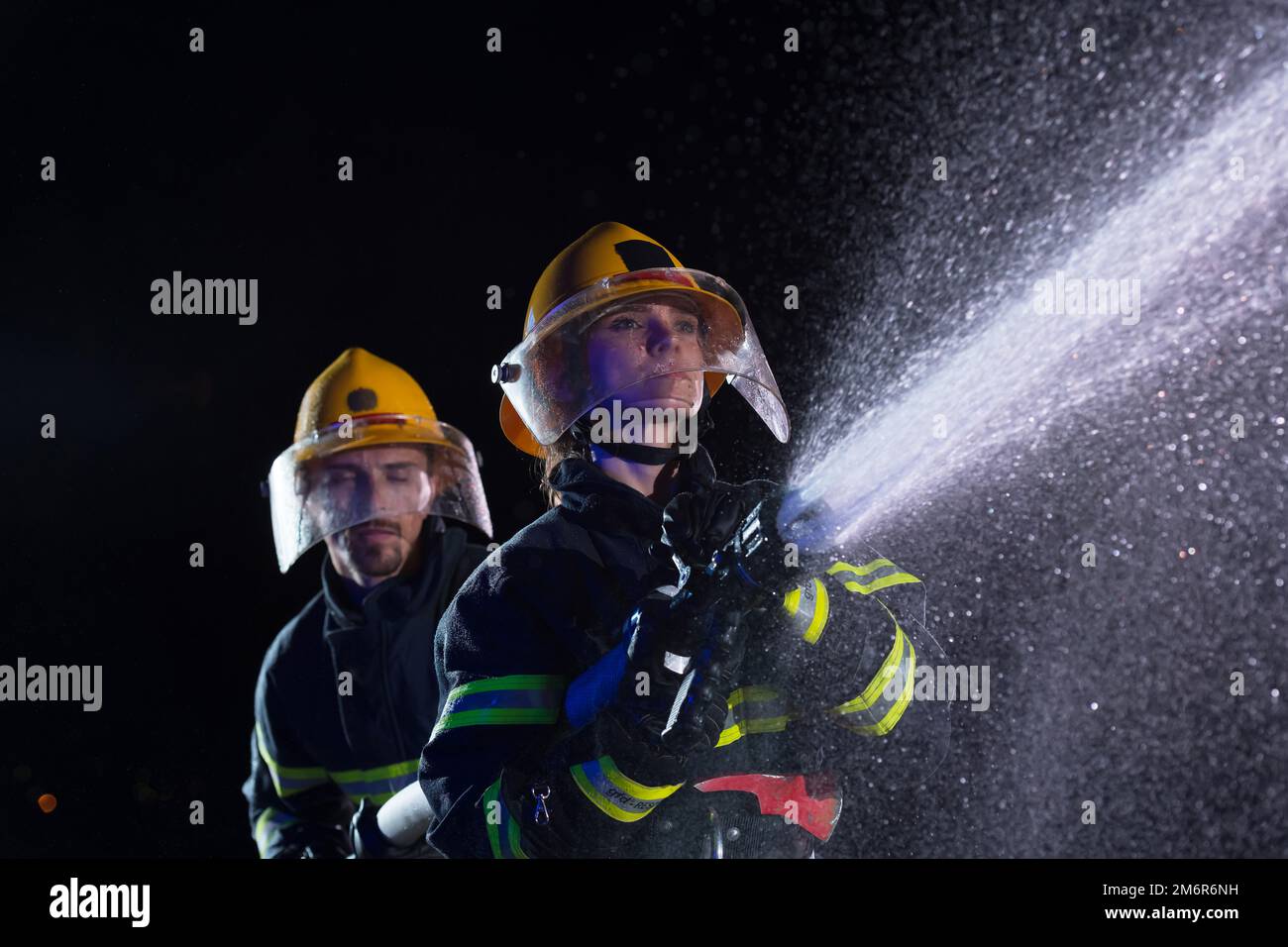 Les pompiers utilisent un tuyau d'eau pour éliminer les risques d'incendie. Équipe de pompiers ...