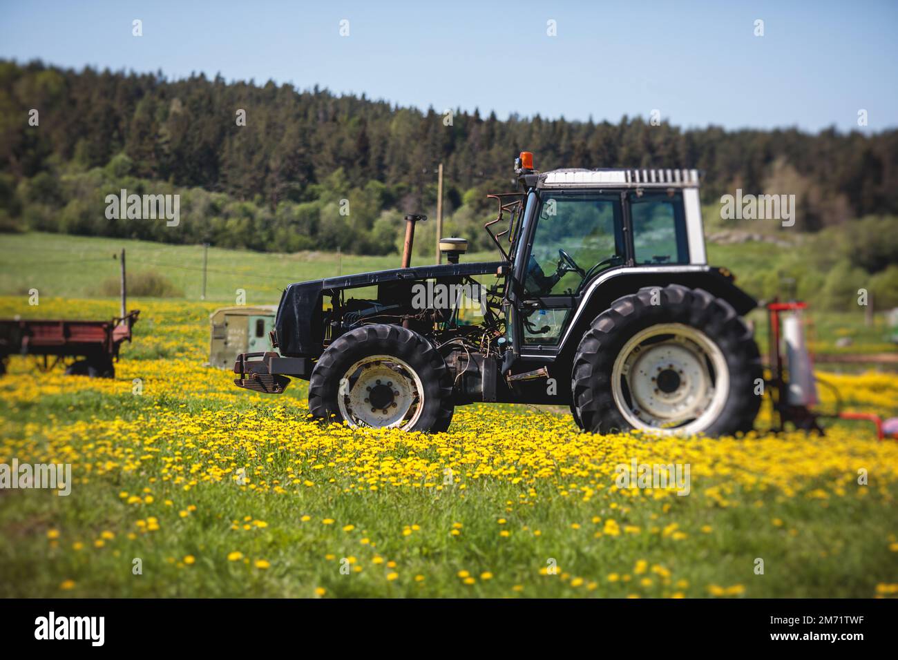 Tracteur équipé d'un système de herses à disque sur le champ agricole ...