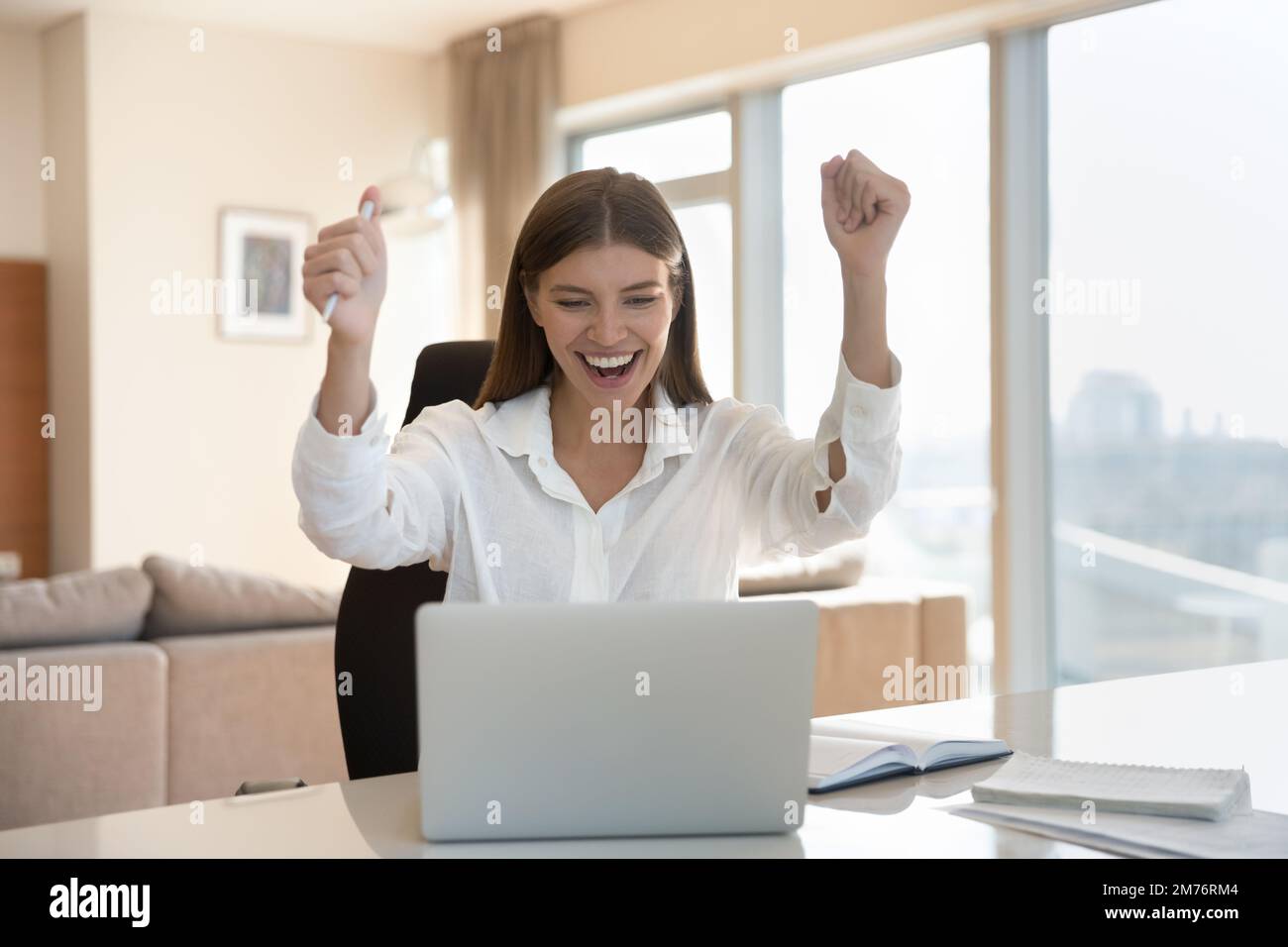 Une femme a lu un e-mail sur un ordinateur portable pour fêter son ...
