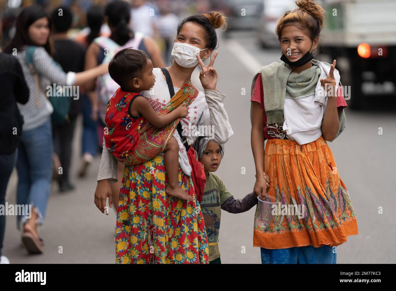 Deux filles Philippines avec de jeunes enfants de la communauté de ...