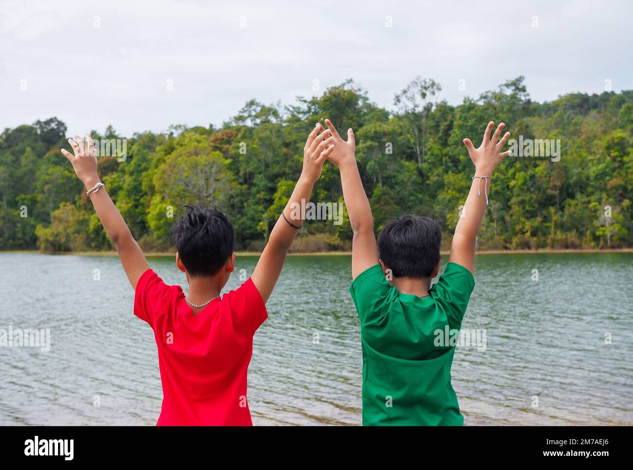 Deux frères tenant les mains debout sur les rives du réservoir. Le ...
