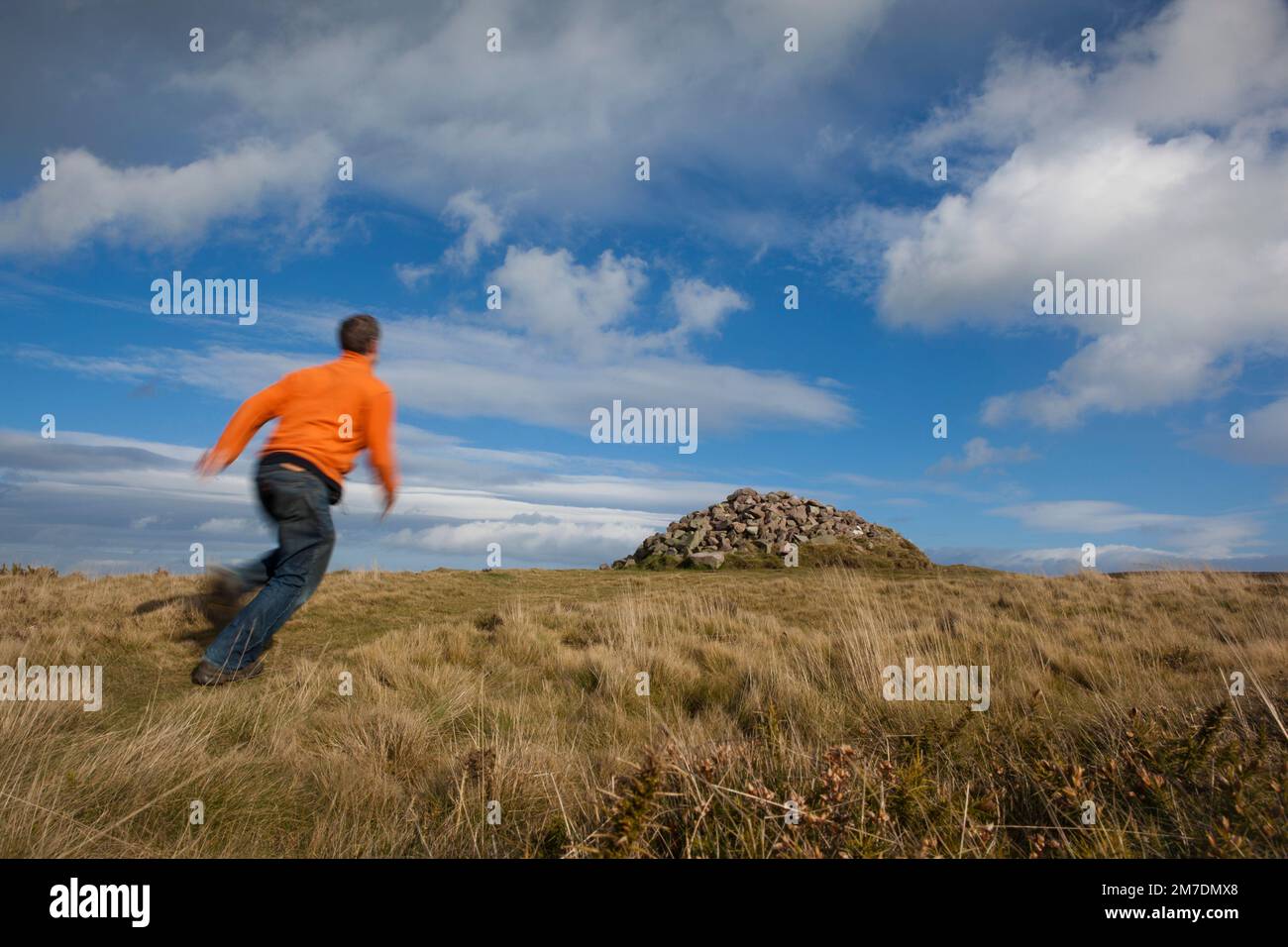 Un marcheur court les derniers mètres jusqu'à un monticule de pierre ...