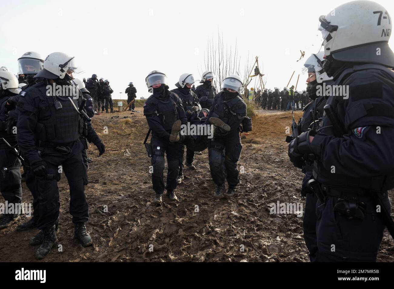 Police officers carry away a demonstrator to clear a road at the ...