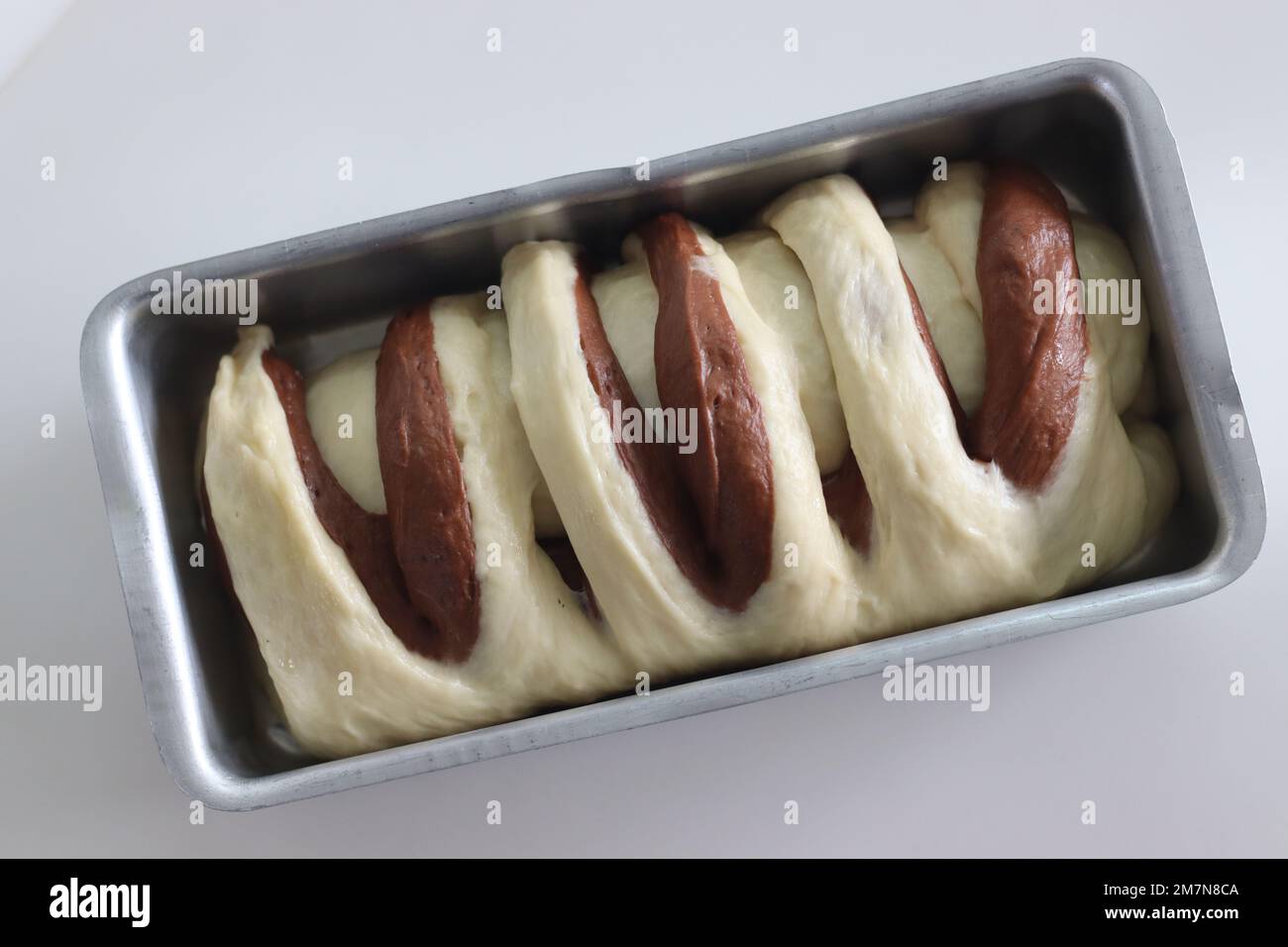 Pâte tourniée placée à l'intérieur d'un moule à pain avant de cuire le ...