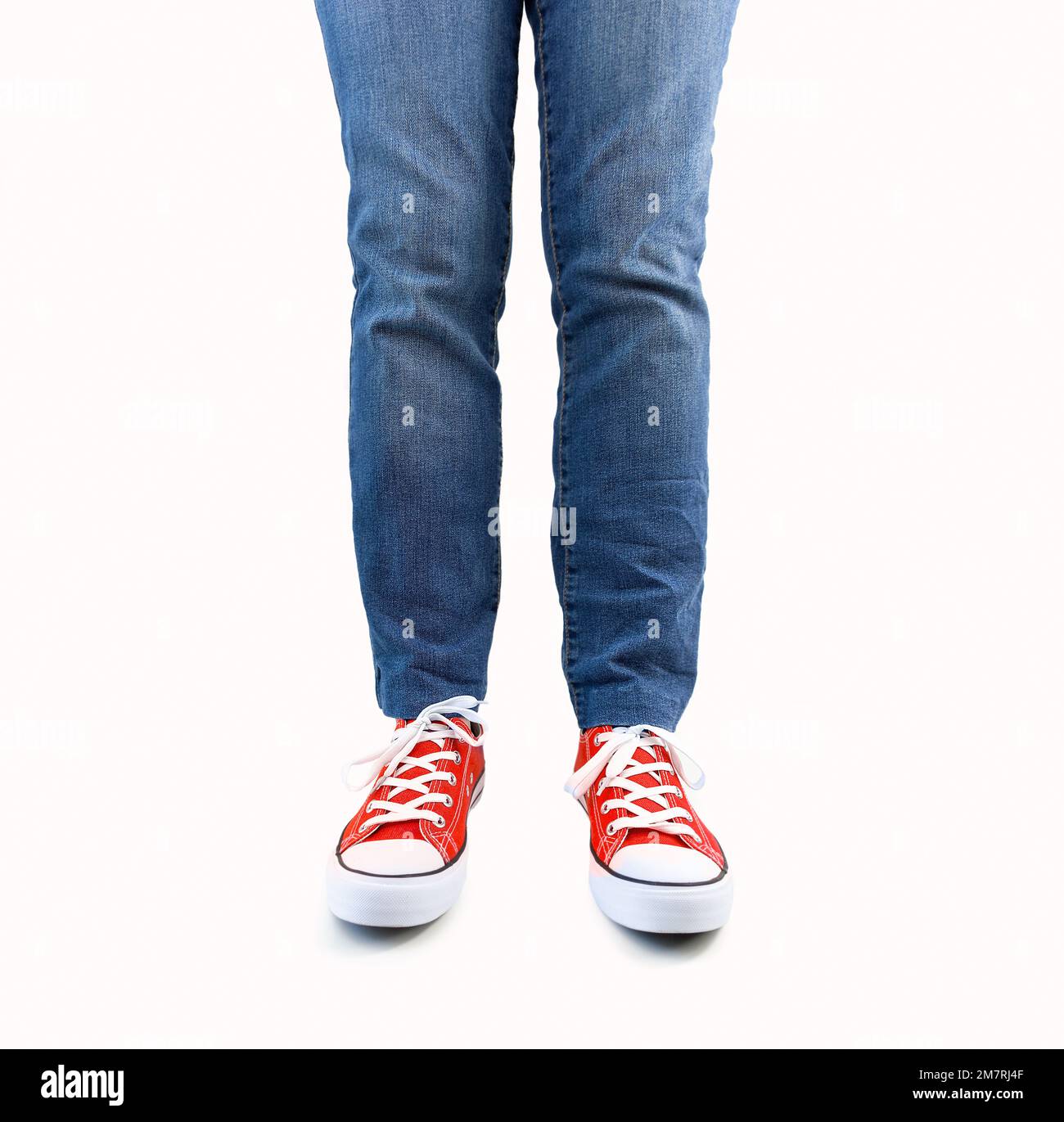 Photo en studio des jambes d'une femme avec jeans et baskets rouges ...