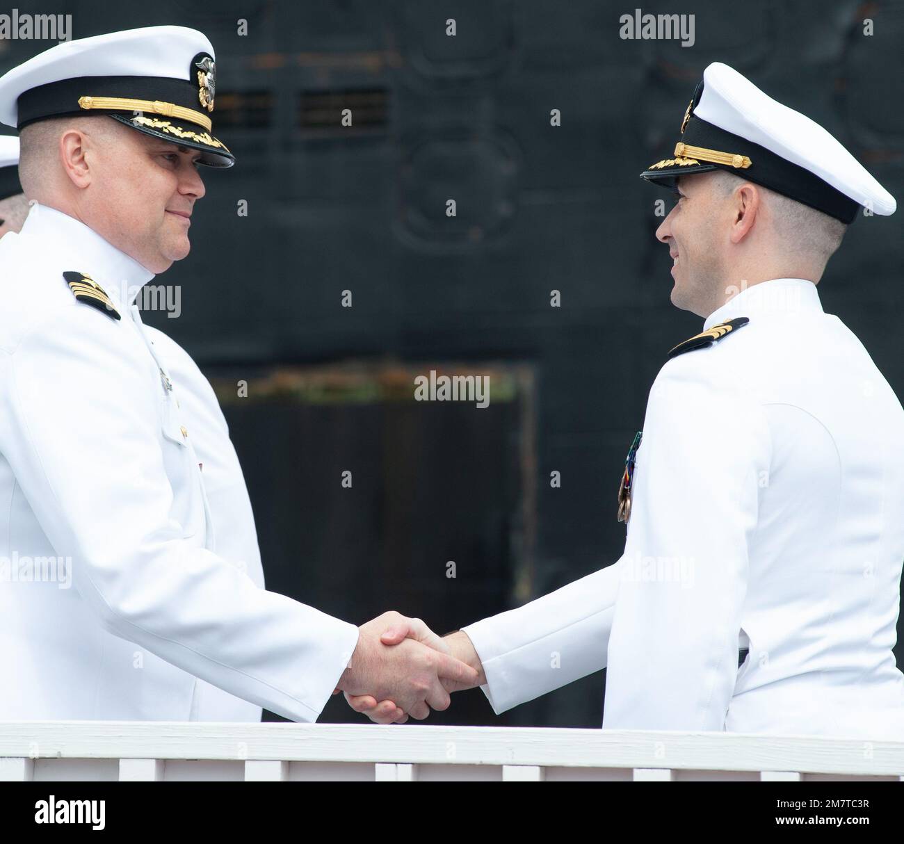 Cmdr. Douglas Sattler, Jr., à gauche, félicite Cmdr. Alan Mardegian ...