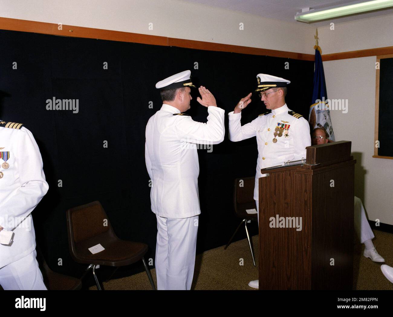 Le commandant (CDR) Kenneth R. Guarino, à gauche, est soulagé par le ...