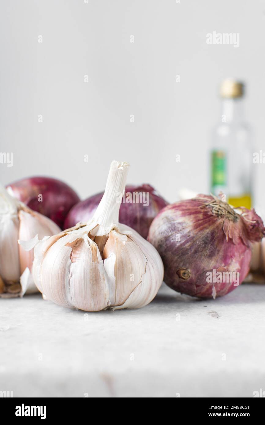 Bulbe d'ail et oignons sur un plateau en marbre, ail avec une gousse ...
