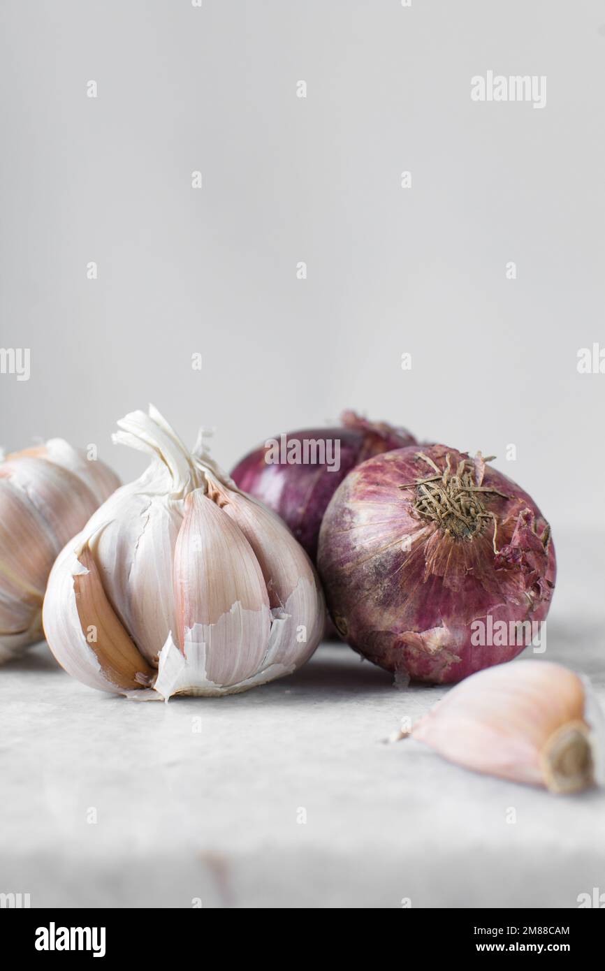 Bulbe d'ail et oignons sur un plateau en marbre, ail avec une gousse ...