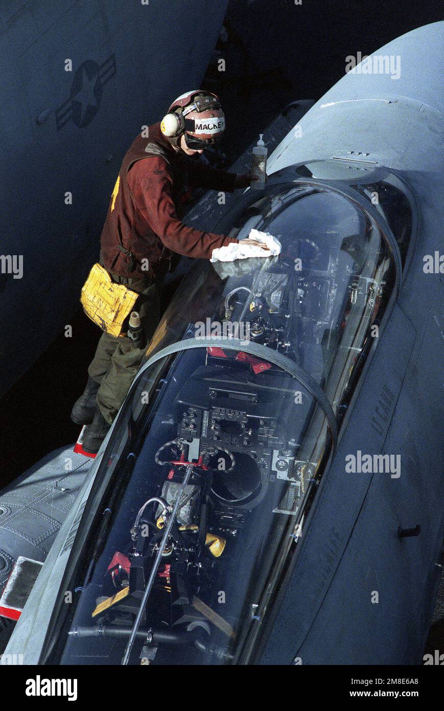 Un commandant de bord polit la voûte d'un F-14A Tomcat sur le plateau ...