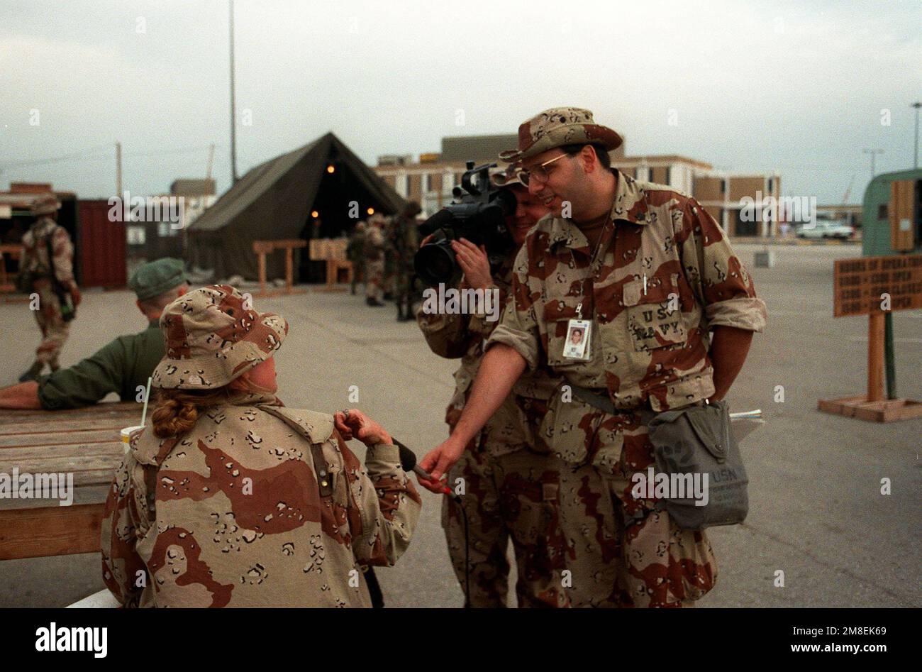 Le photographe Mate 2nd Class Keith Tayman, au centre, filme un membre ...