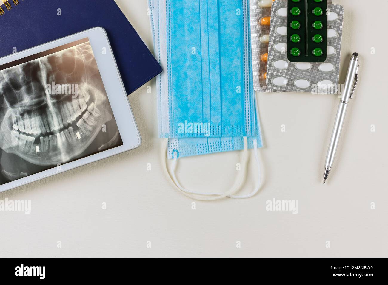 Le médecin examine les radiographies dentaires panoramiques sur une tablette numérique afin de ...