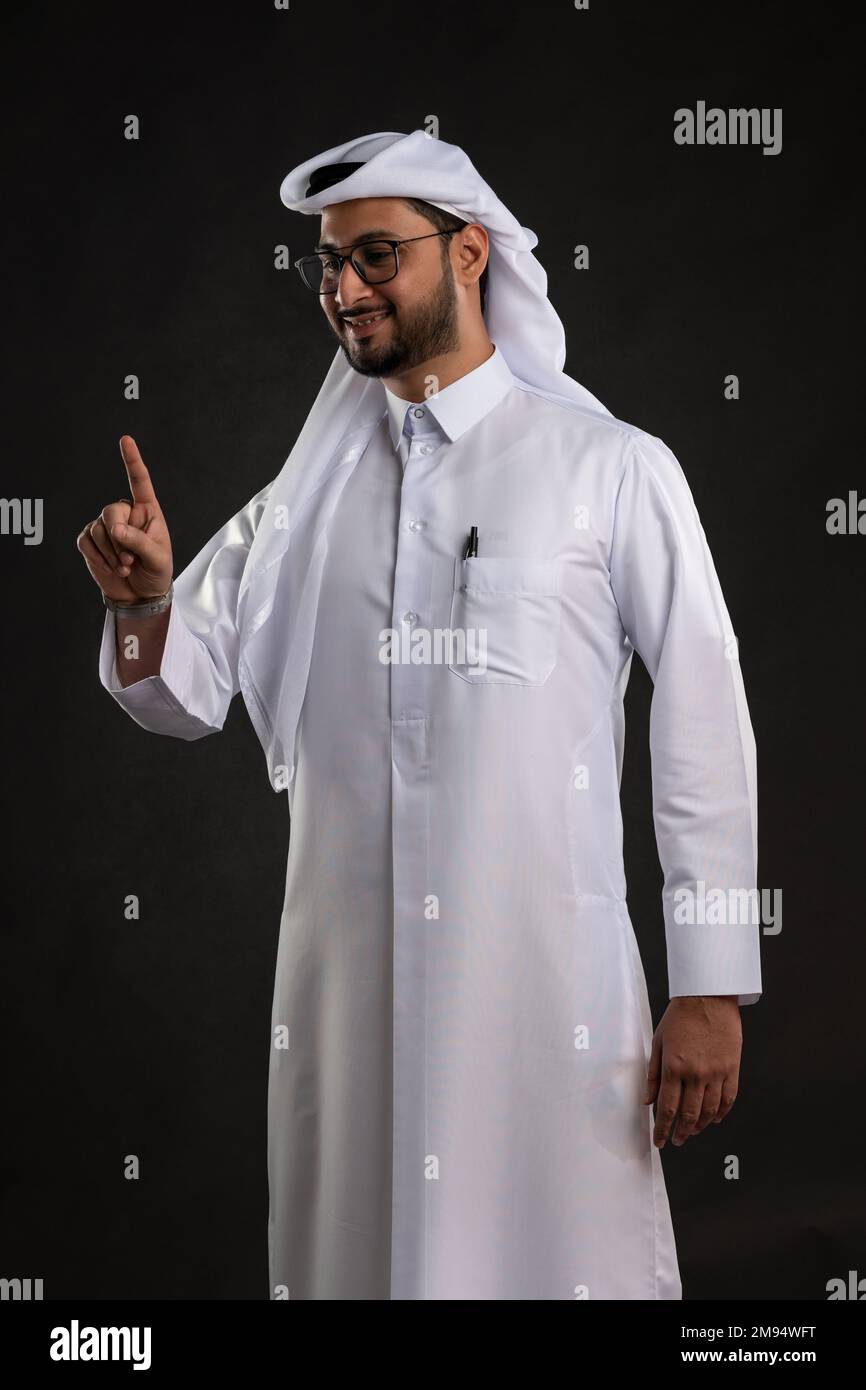 Arabe Qatari homme utilisant le tablate et posant sur un fond isolé ...