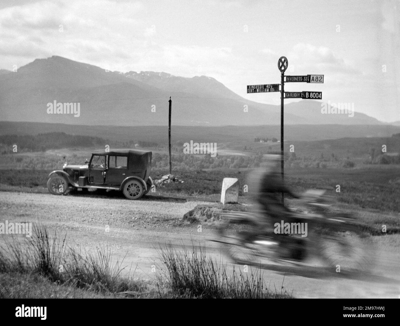 Une voiture et une moto se passant les uns les autres sur une route de ...