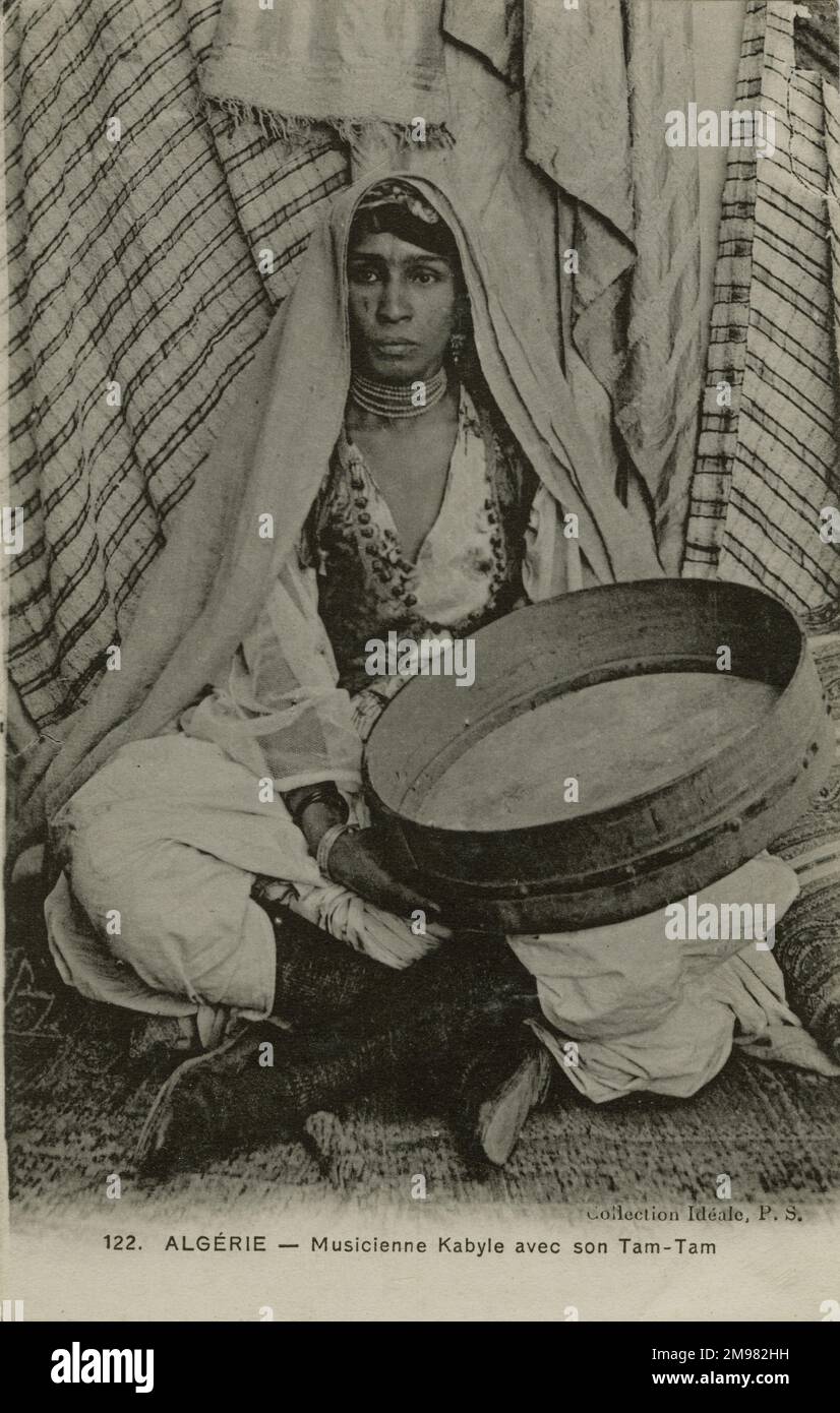 Une musicienne de Kabyle est assise à pattes croisées tenant son Tam ...