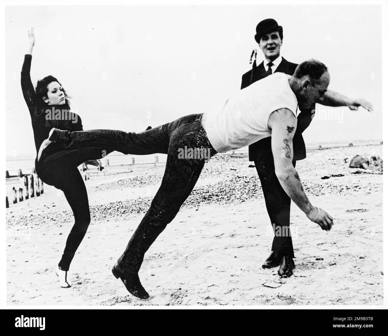 Emma Peel envoie un méchant alors que John Steed admire son œuvre, de ...