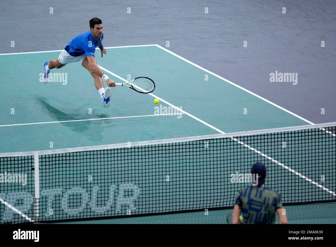 Serbia's Novak Djokovic, top, stretches to return the ball to Denmark's Holger Rune during their ...