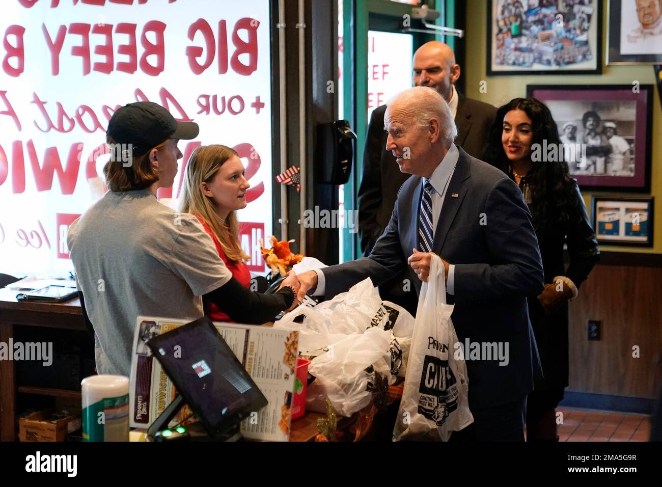 President Joe Biden chats with an employee while picking up a meal at ...