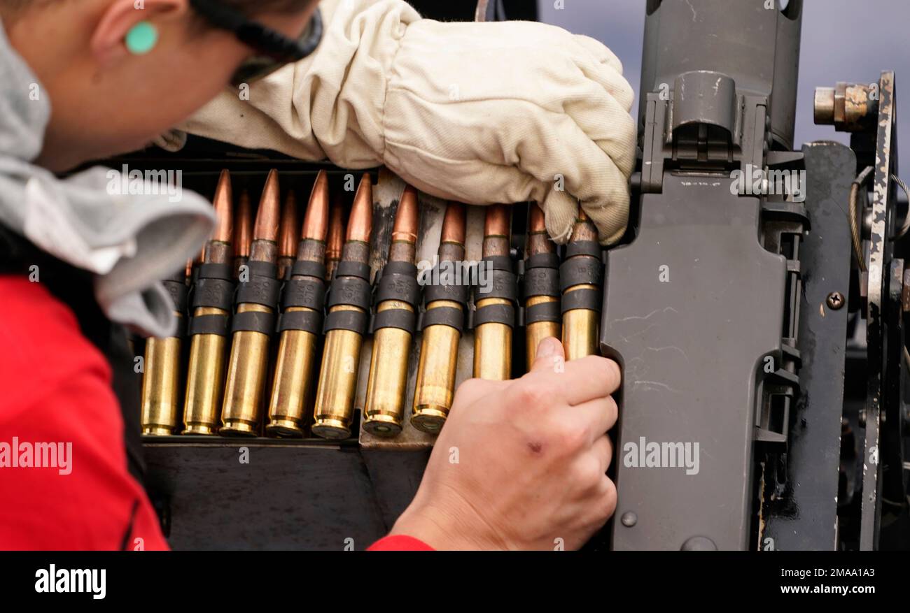 A weapons officer loads a 50-caliber machine gun for a live fire drill ...
