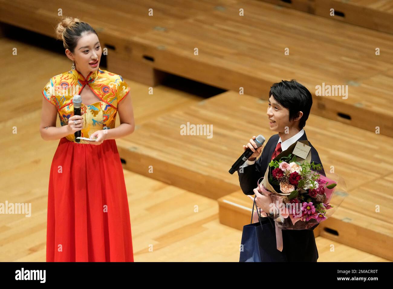 Erhu player Zhang Hina, left, listens as figure skater Yuzuru Hanyu speaks in Chinese at the ...