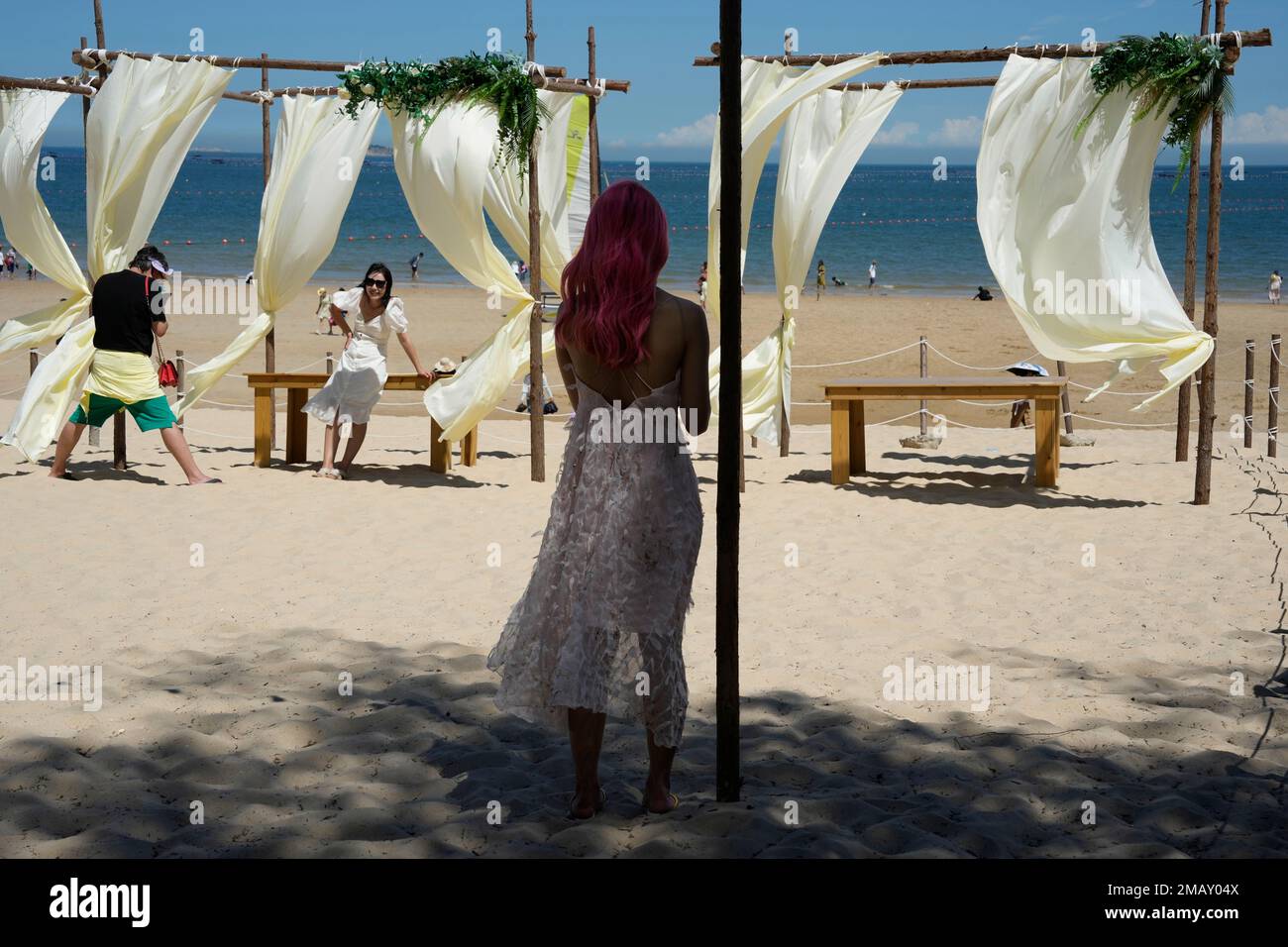 Tourists take photos on a beach along the Taiwan Straits in Pingtan in ...