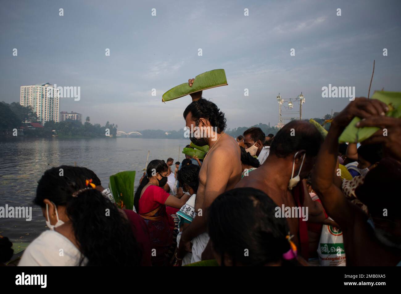 Hindus carry sesame seeds, rice and flowers in banana leaves to immerse ...