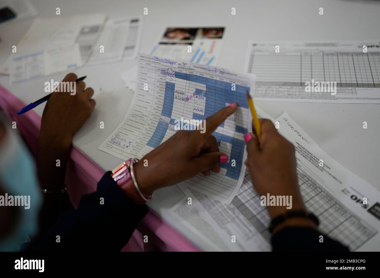 A nurse holds a vaccination card during a free vaccination campaign for ...