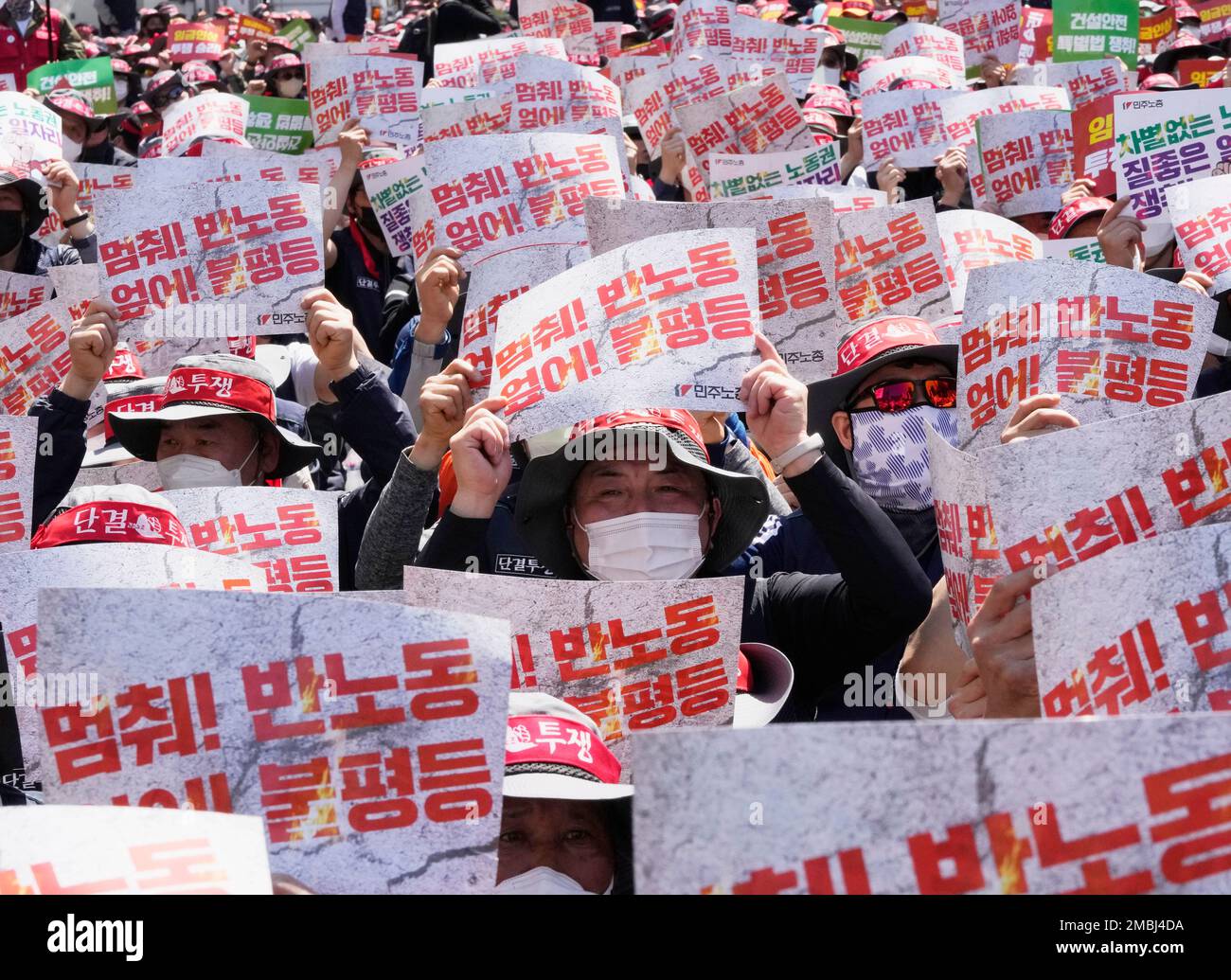 Members of the Korean Confederation of Trade Unions hold up their cards ...