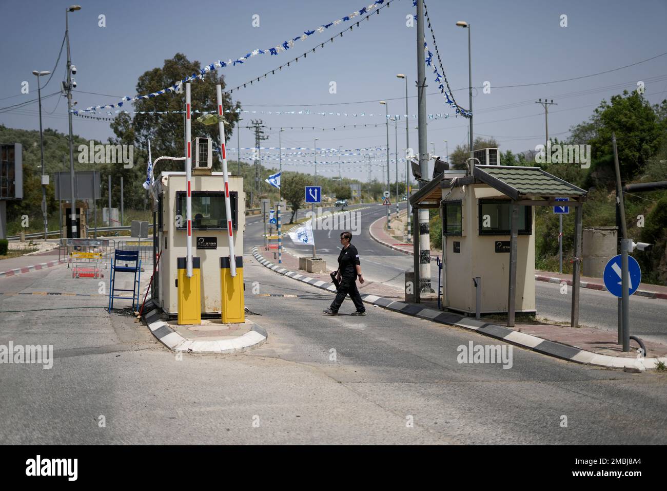 An Israeli security guard secures the entrance to the Jewish settlement ...