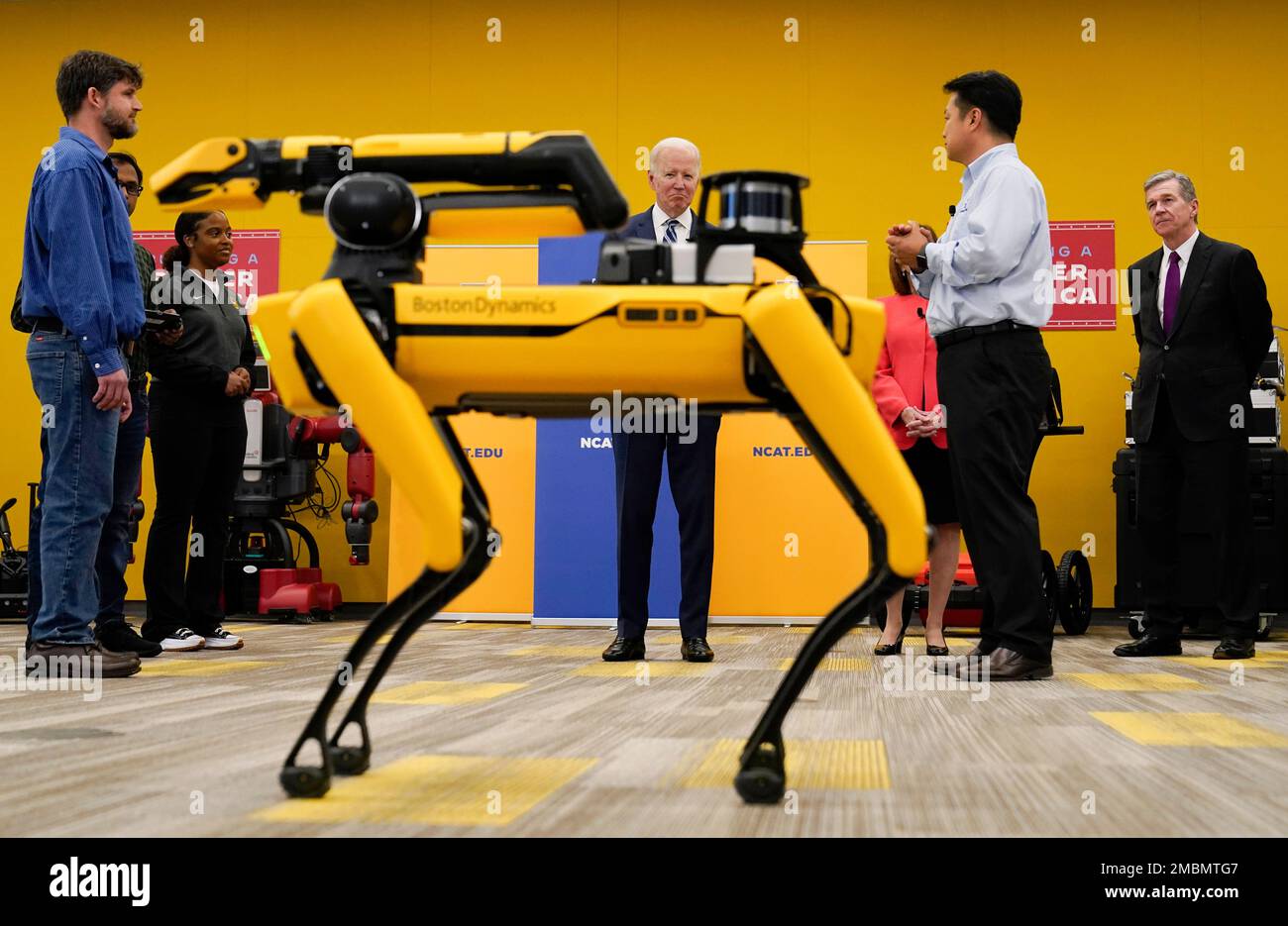 President Joe Biden looks at Spot, a Boston Dynamics robotic dog, during a tour with professor ...