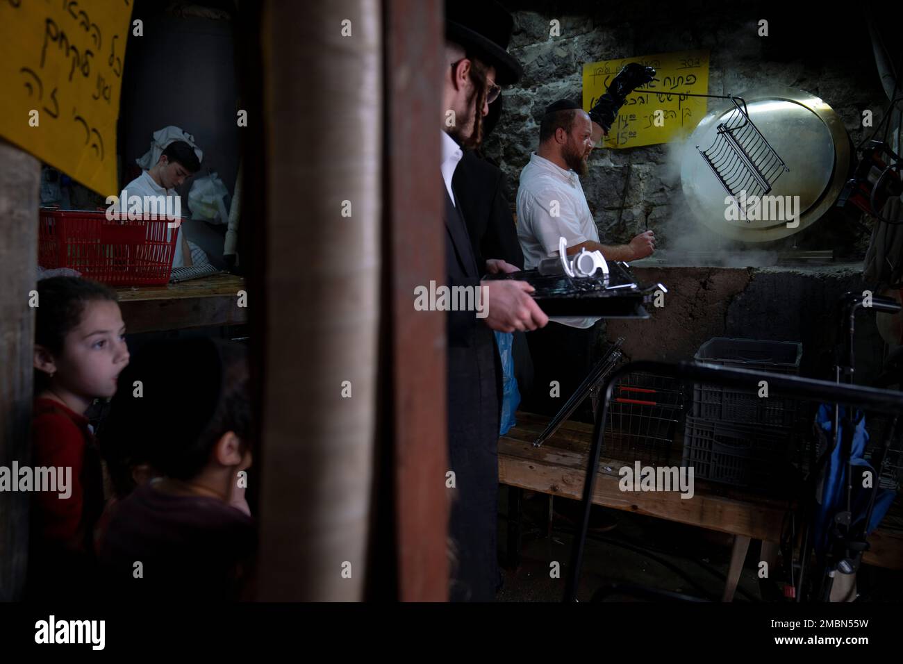 An ultra-Orthodox Jewish man dips cooking utensils in boiling water to ...