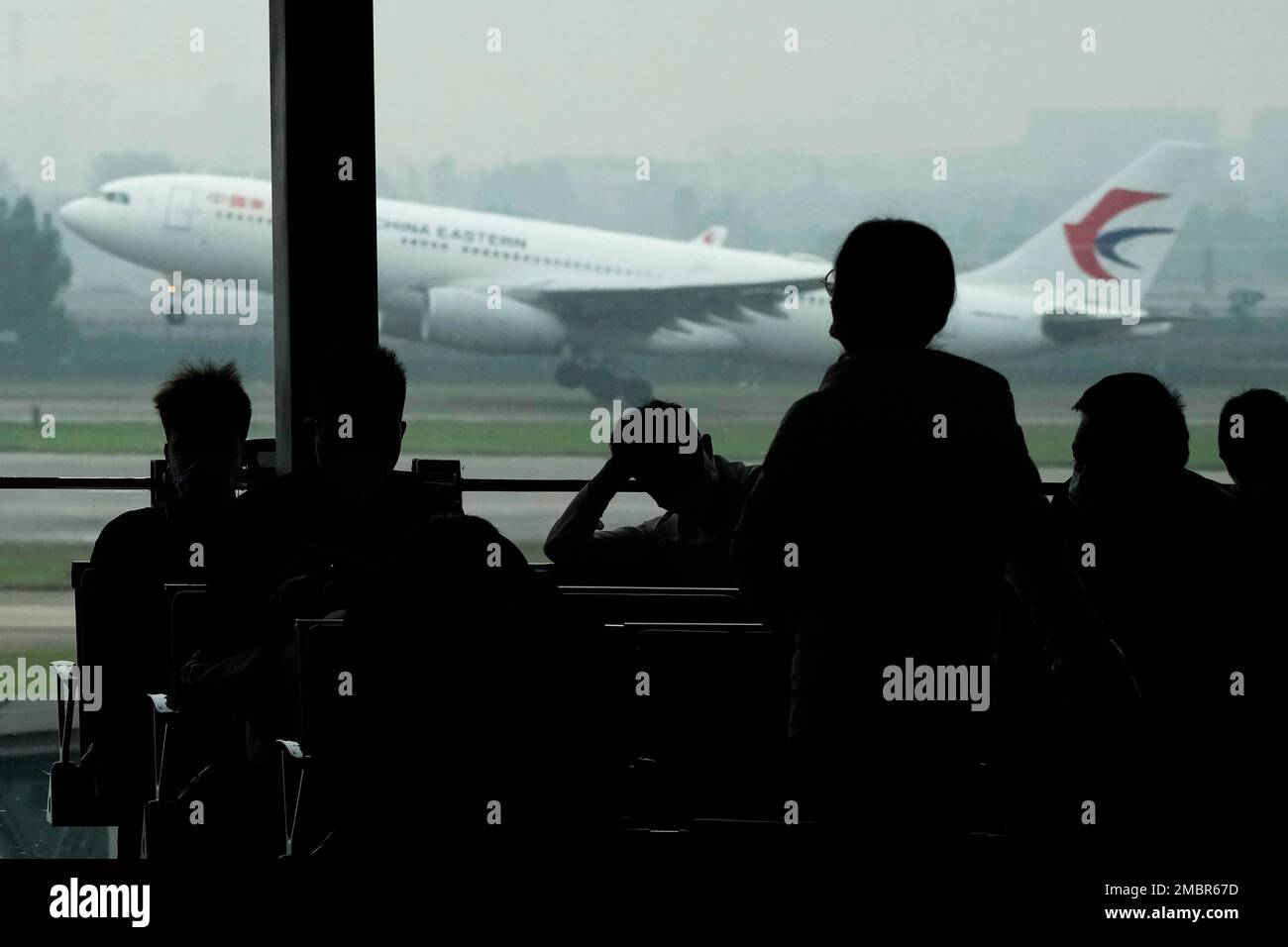 FILE - Passengers wait for their flight as a China Eastern flight takes ...