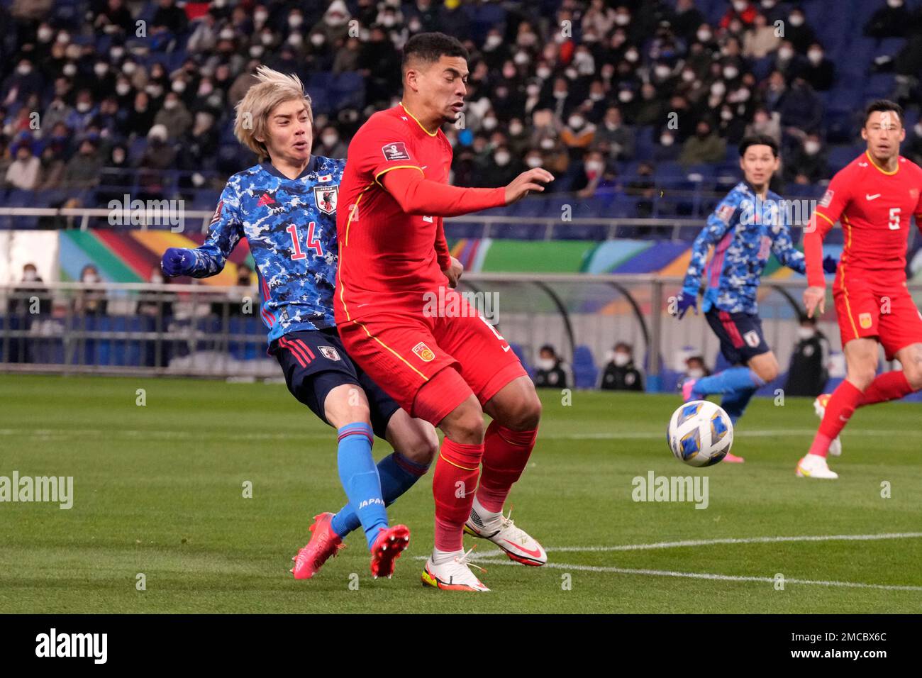 China's Jiang Guangtai, right, fights for the ball against Japan's ...