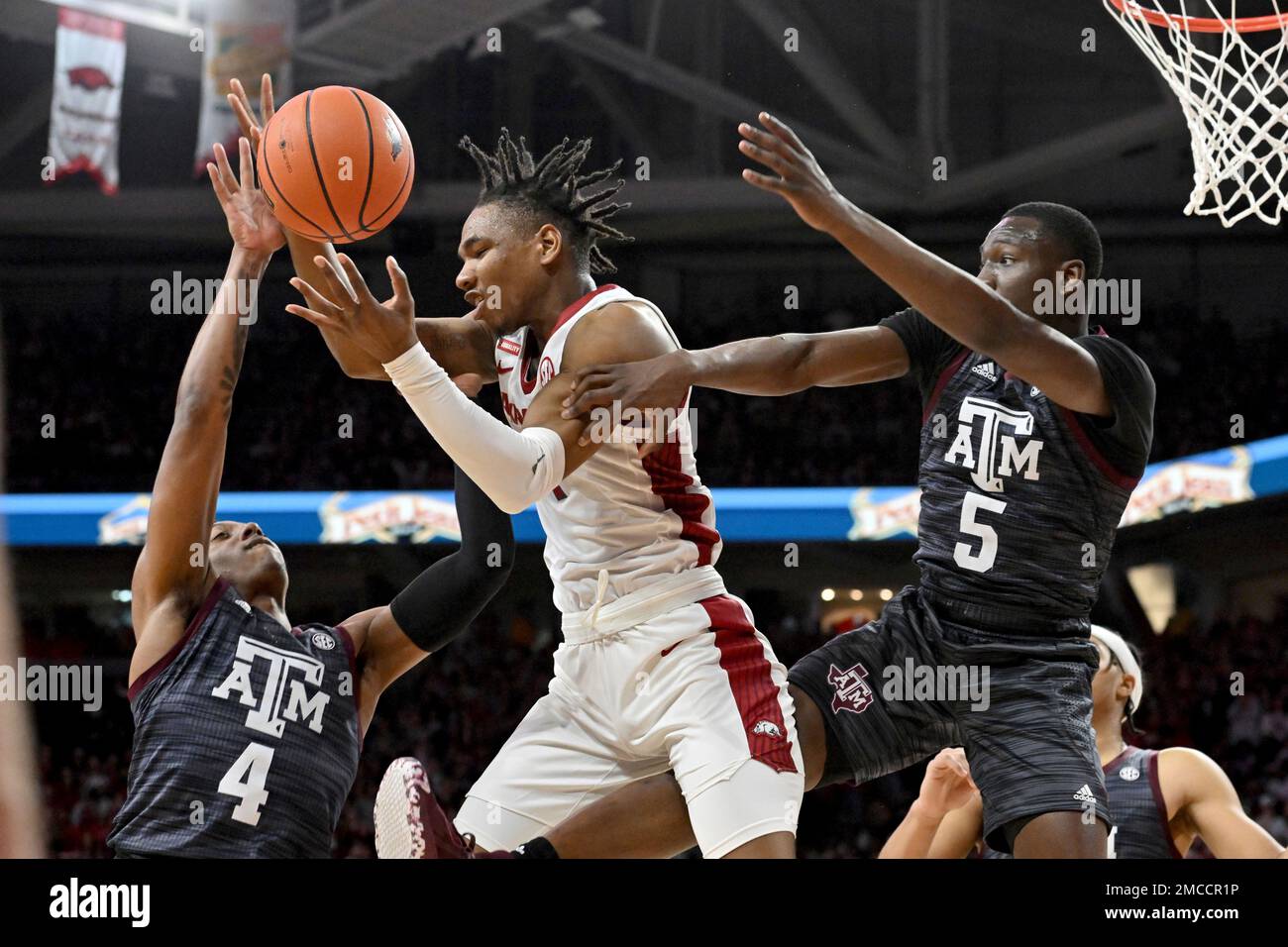 Arkansas guard JD Notae, center, fights for a rebound against Texas A&M's Wade Taylor IV (4) and ...