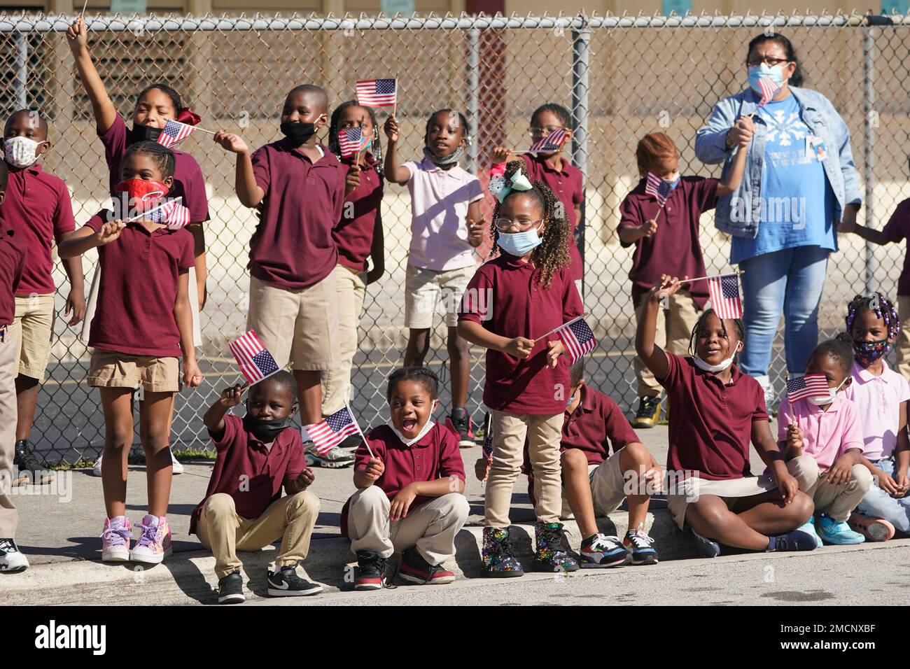 Students at Carrie P. Meek/Westview K-8 Center in Miami, wave at a funeral motorcade carrying ...