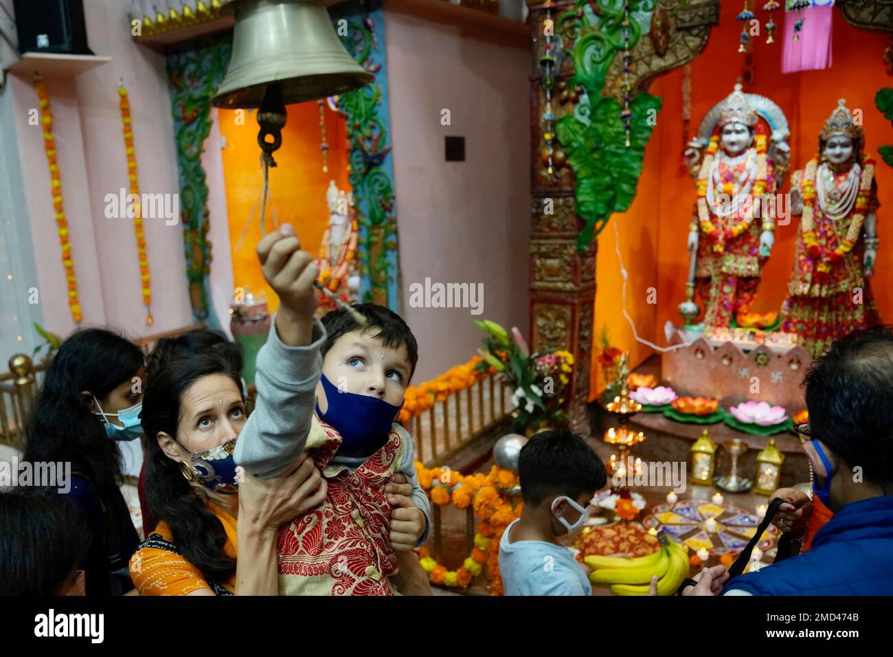 Hindu devotees ring a bell as they pray at a temple during Diwali, the ...