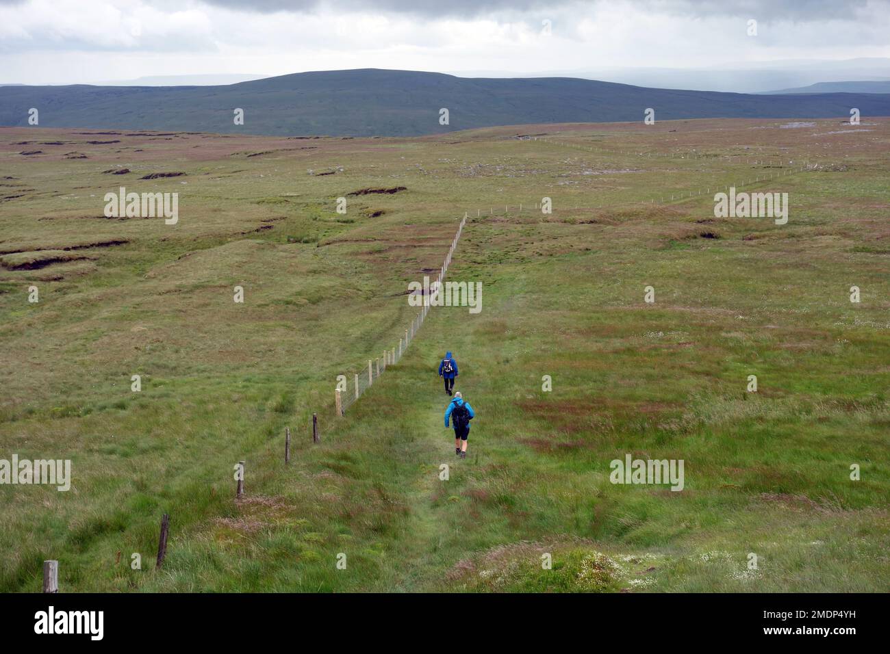 Deux hommes marchant sur Path by Wire Fence de Great Shunner est tombé ...