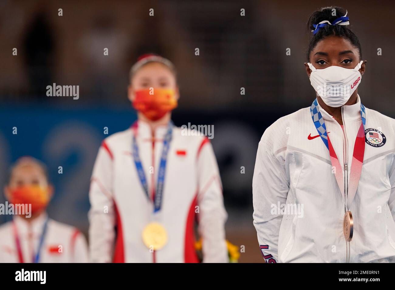 Bronze medalist Simone Biles, of the United States, right, listens to ...