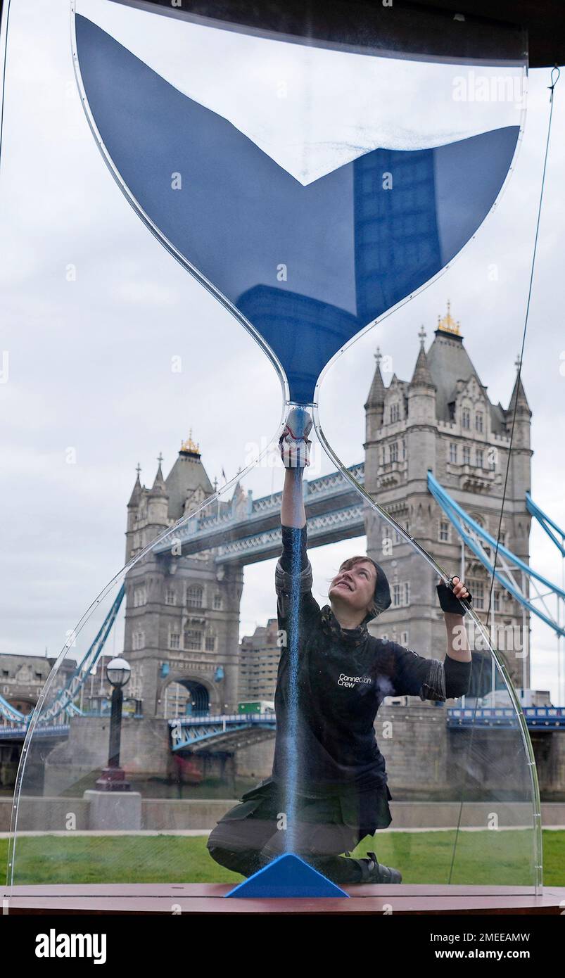 A woman cleans an hourglass installation by clean water charity ...