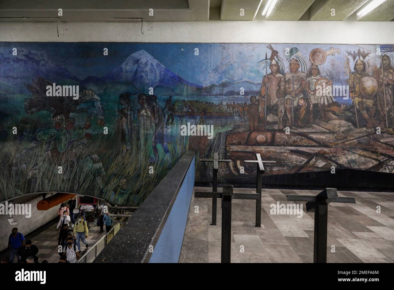 People walk under murals representing the foundation of the Aztec ...