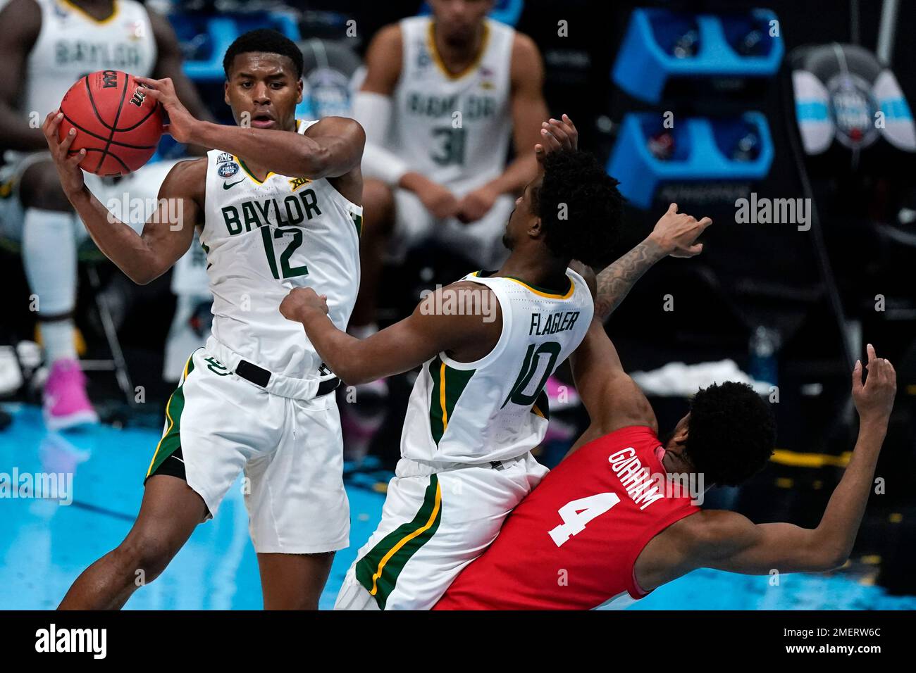 Baylor guard Jared Butler (12) passes over teammate guard Adam Flagler ...