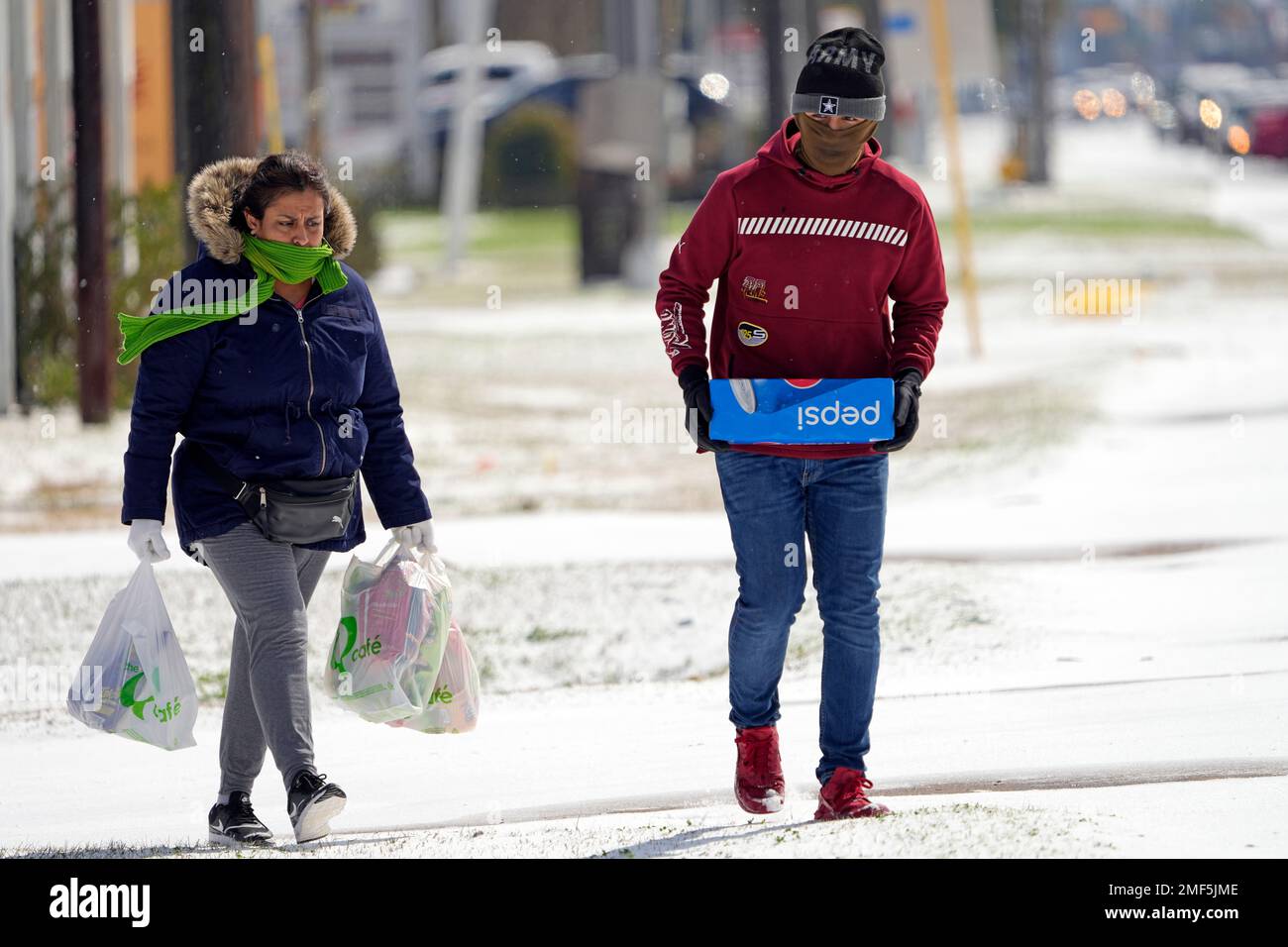 Lia Ubidia, left, and her son, Andrew Velarde, carry groceries as they ...
