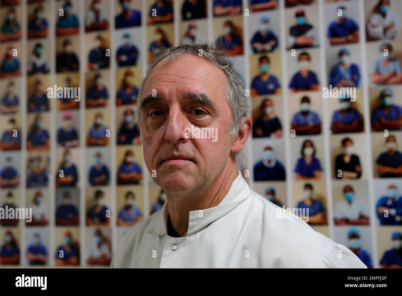 Dr. Philippe Montravers poses in front of a collection of portraits of ...