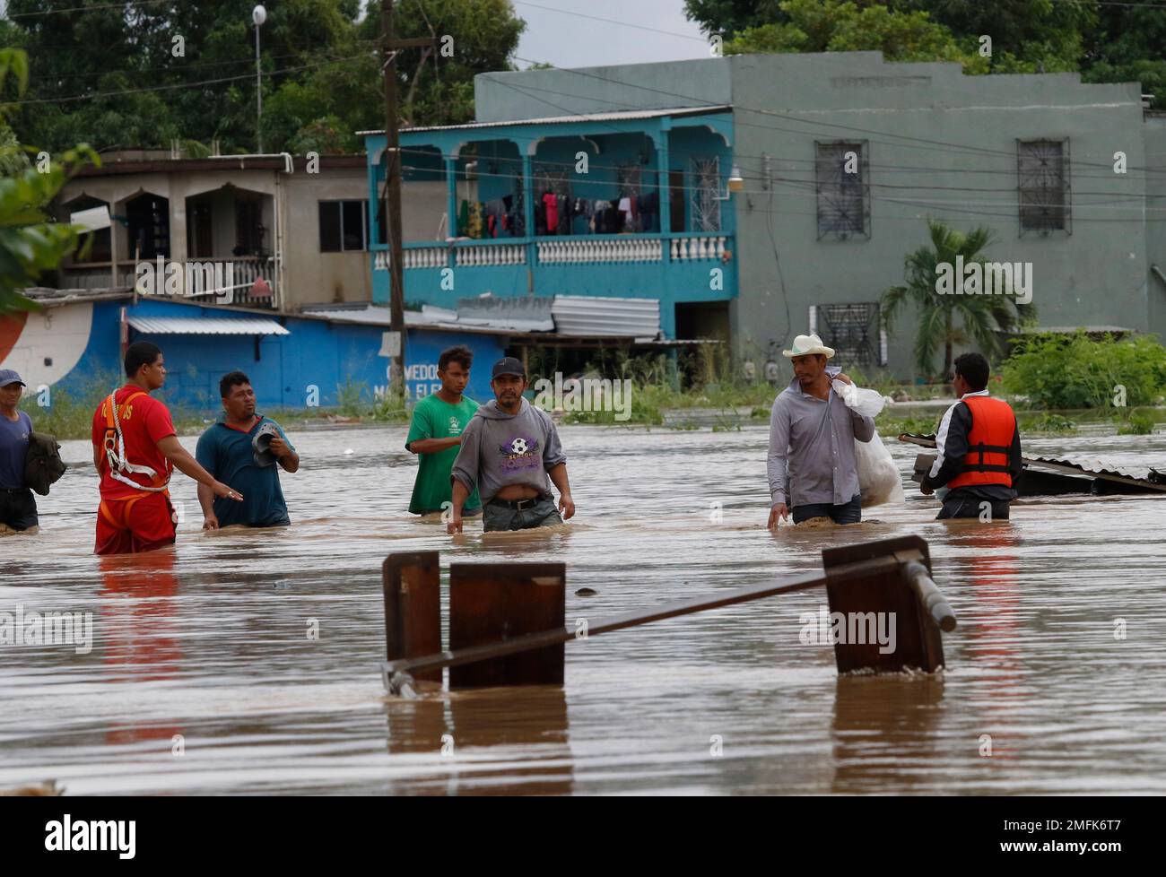 Men wade through a street flooded after the passing of Hurricane Iota ...