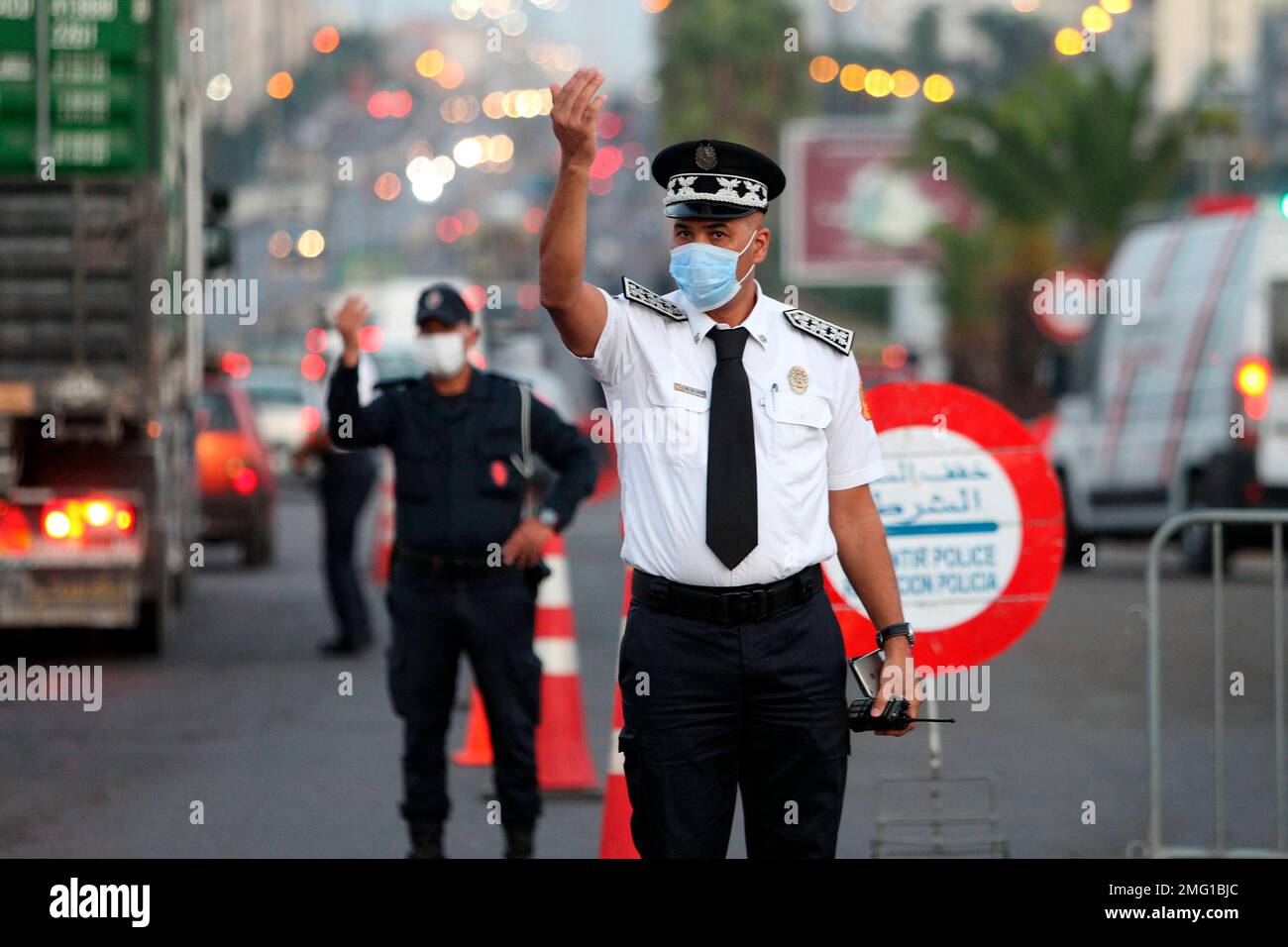 Moroccan police officers wearing masks direct the traffic at a ...